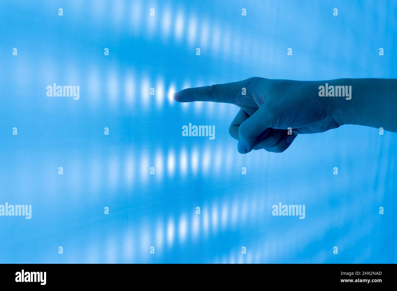 hand and led touch screen blue light science and technology background ...