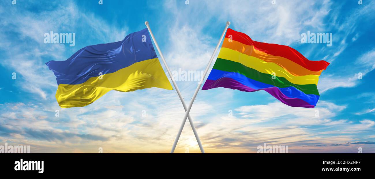 crossed national flags of Ukraine and LGBT Pride flag waving in wind at ...