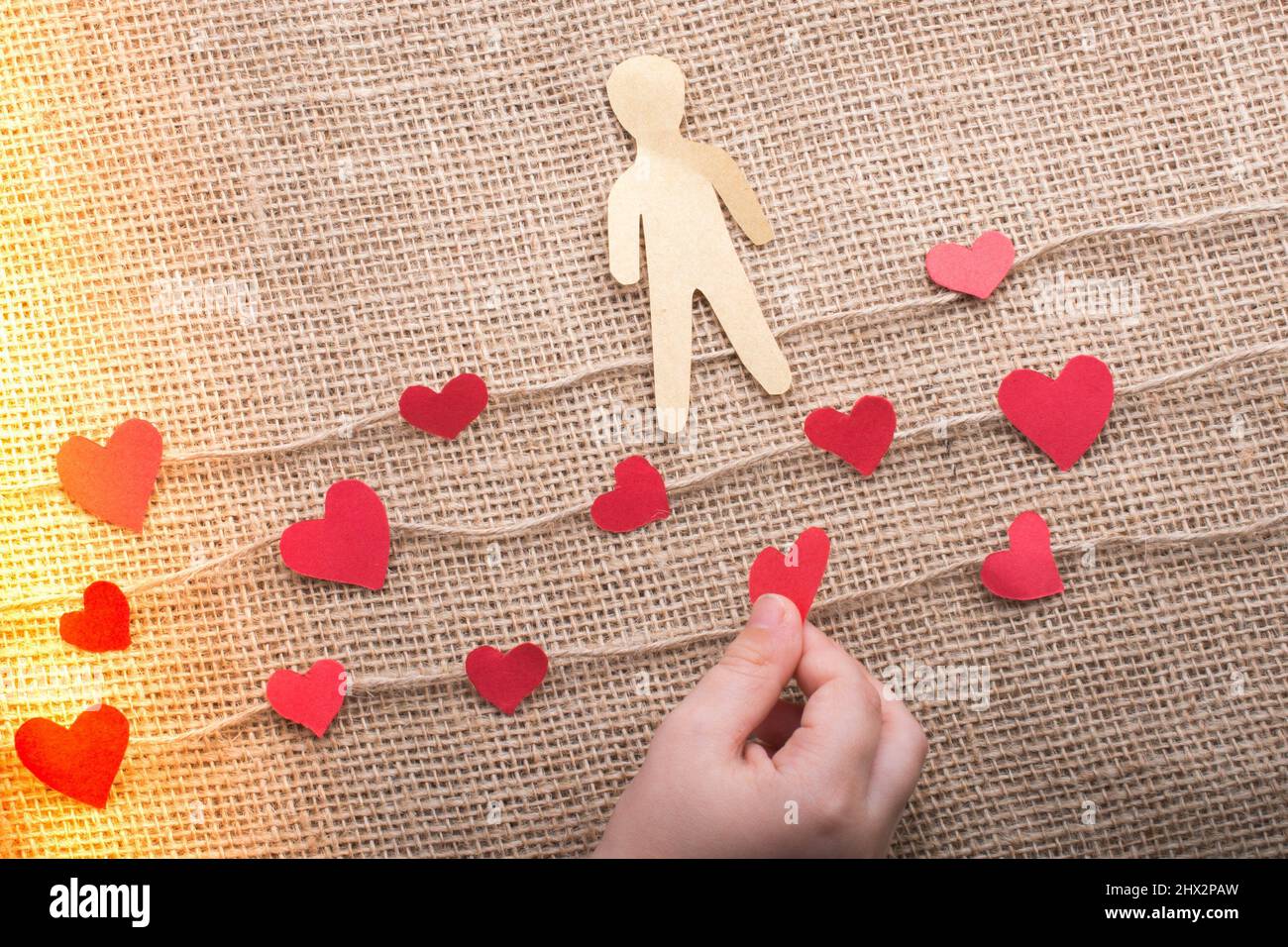 Paper man and heart icons on linen threads on canvas Stock Photo - Alamy