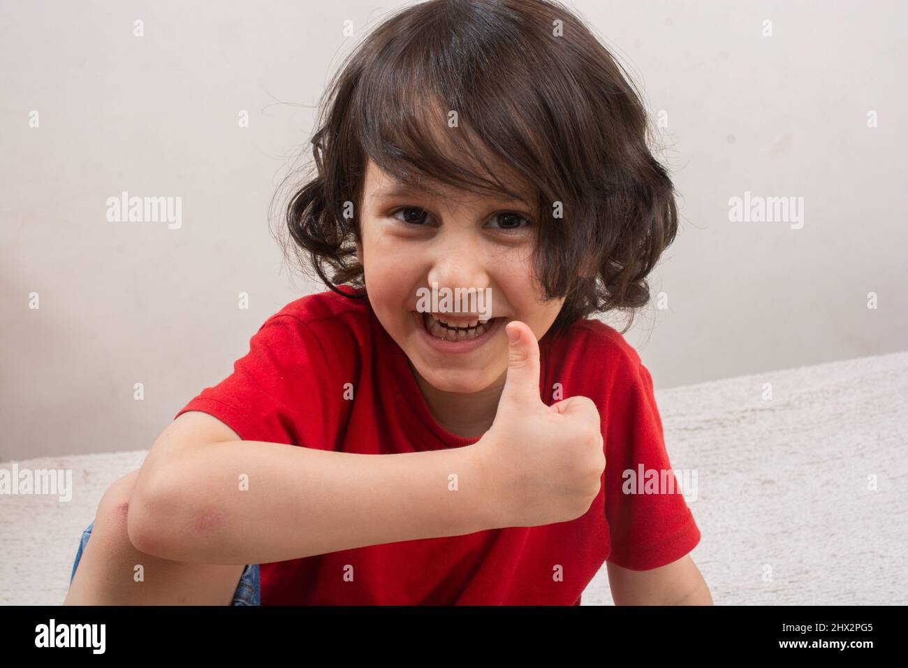 Cute little boy with a thumbs up showing sign ok Stock Photo - Alamy