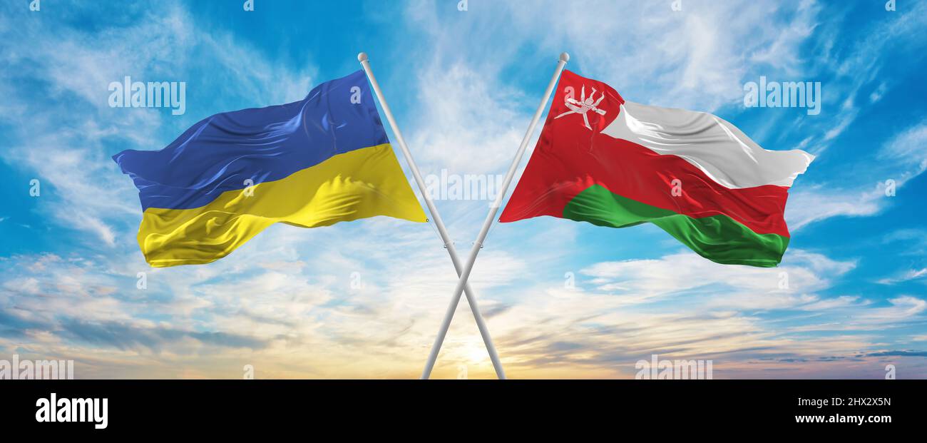 crossed national flags of Ukraine and Oman flag waving in wind at ...