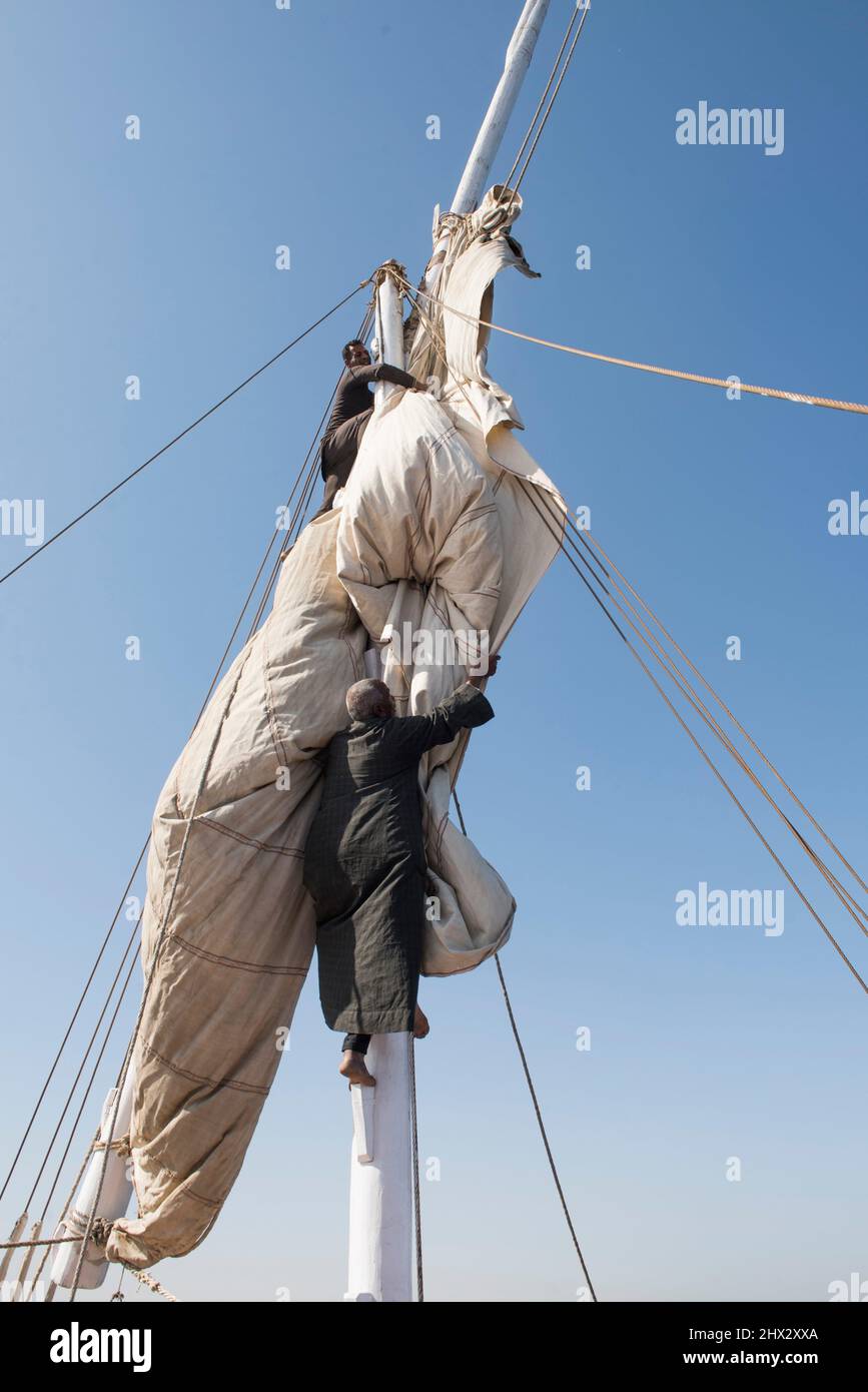 Crew working on a dahabeah under sail, passenger river boat of the ...