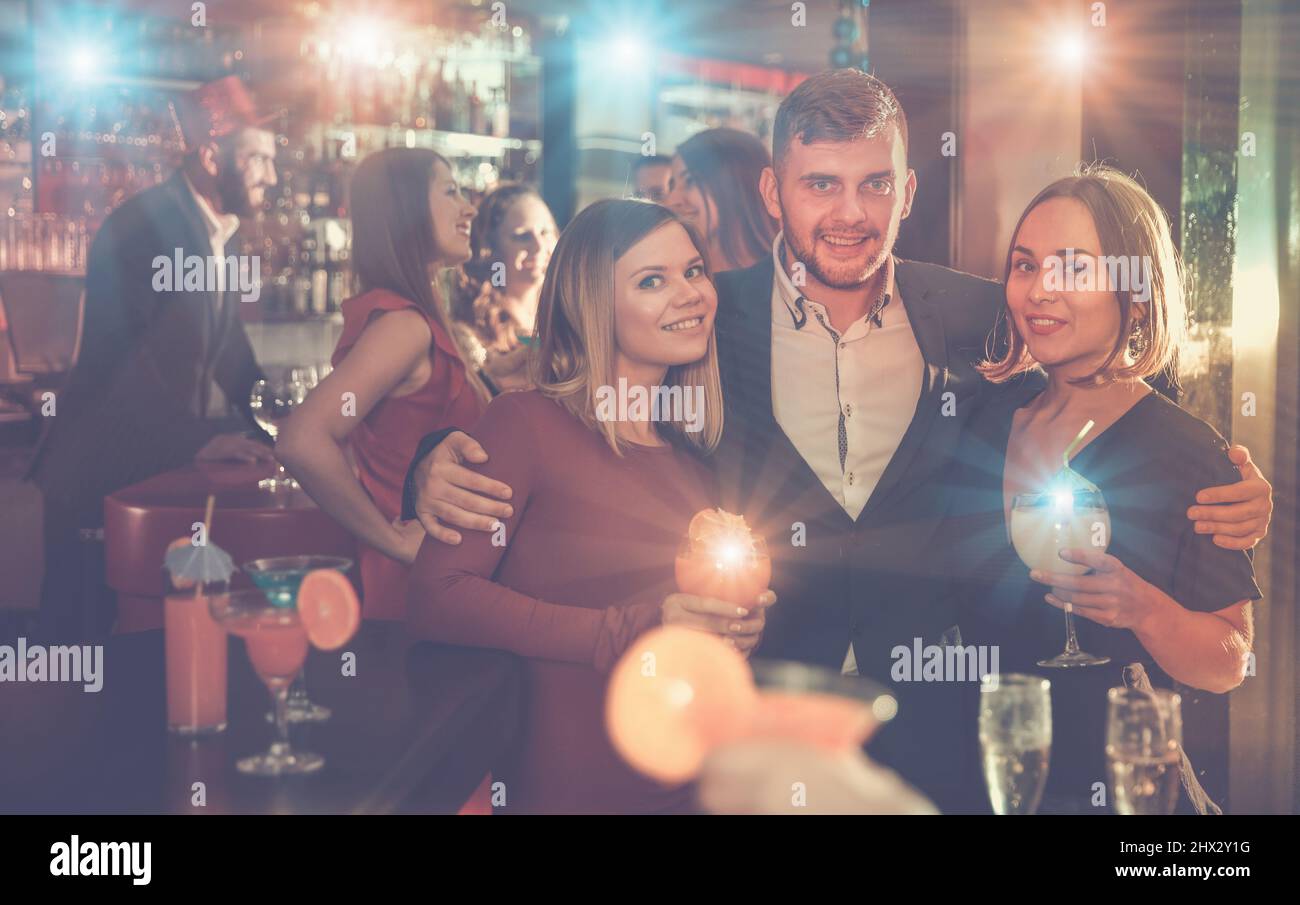 Man and two women at nightclub Stock Photo - Alamy