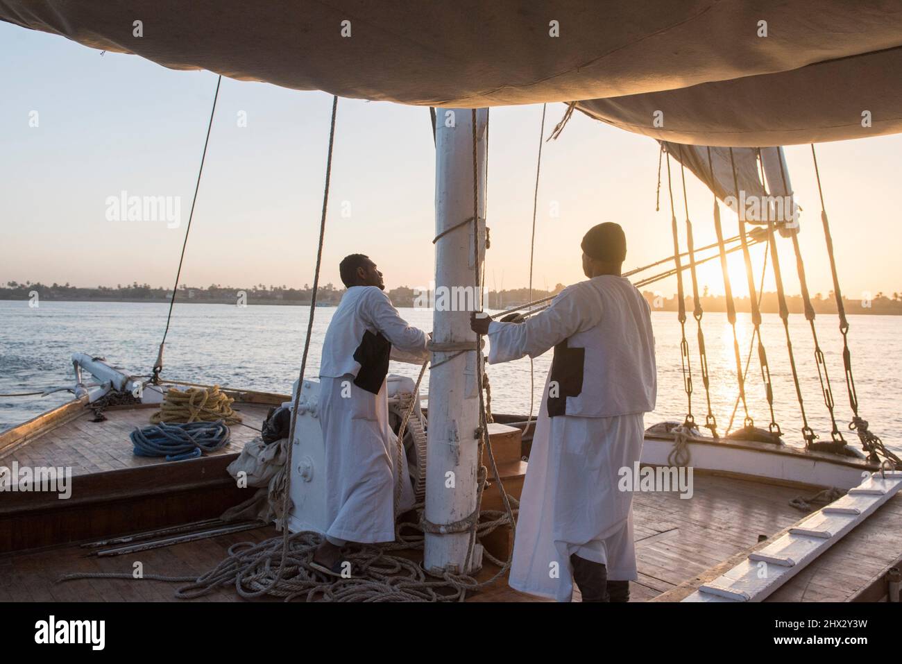 Crew working on a dahabeah under sail, passenger river boat of the ...