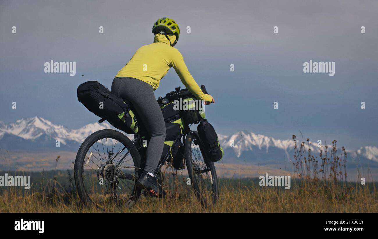 The woman travel on mixed terrain cycle touring with bikepacking. The ...