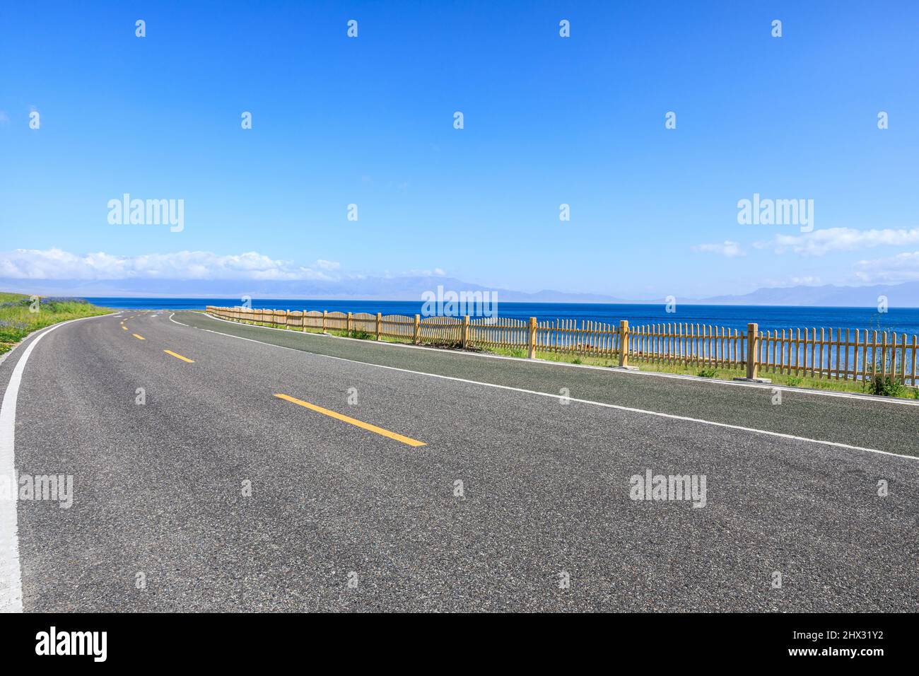 Empty asphalt highway and azure ocean nature scenery under blue sky ...