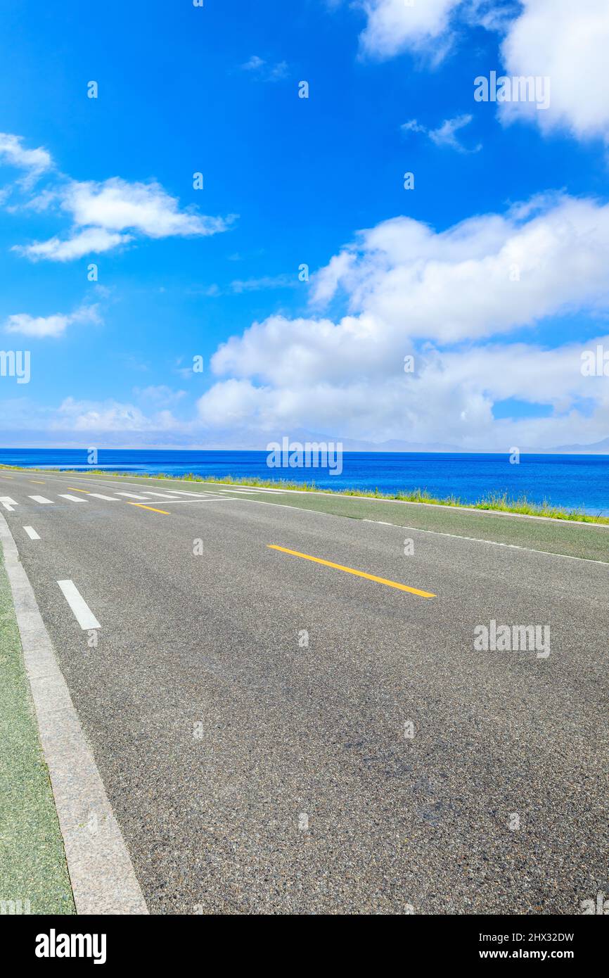 Empty asphalt highway and azure ocean nature scenery under blue sky ...