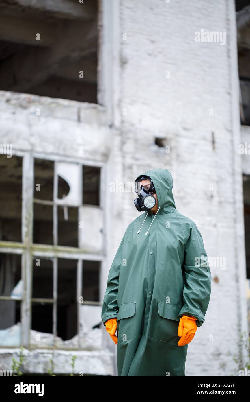 A dosimetrist scientist in protective clothing and a gas mask checks ...
