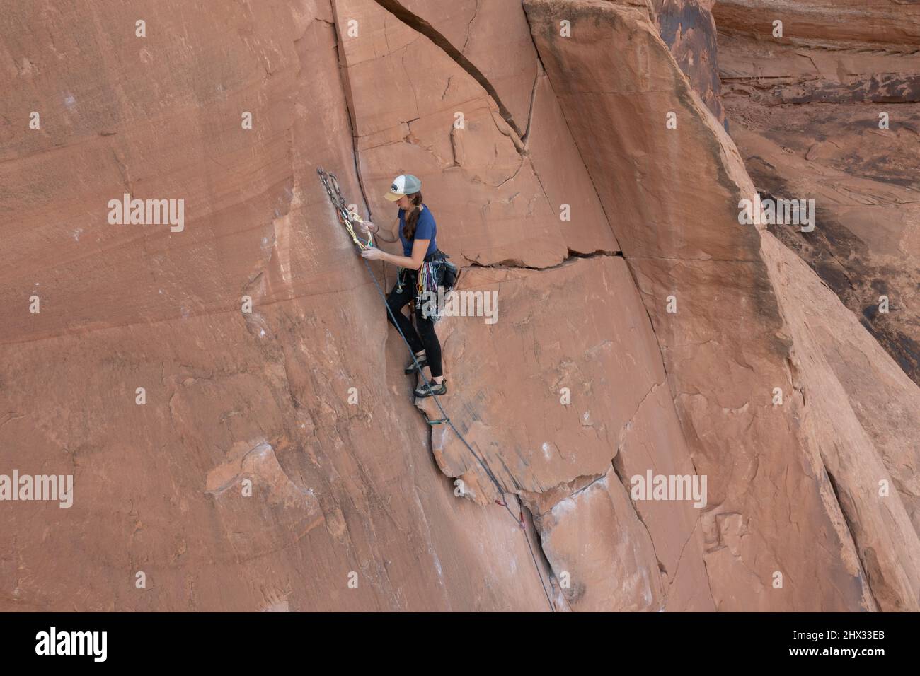 A female lead climber sets up a rope anchor at the top of the Flakes of ...