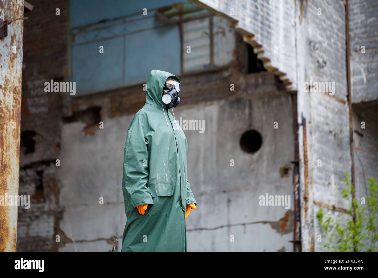 A man with a protective mask and protective clothing examines the ...