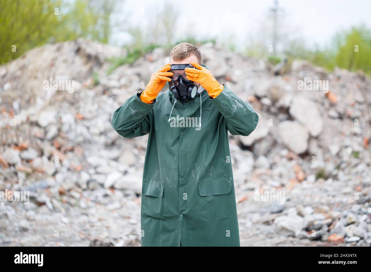 A man takes off a protective mask and he is dressed in protective ...