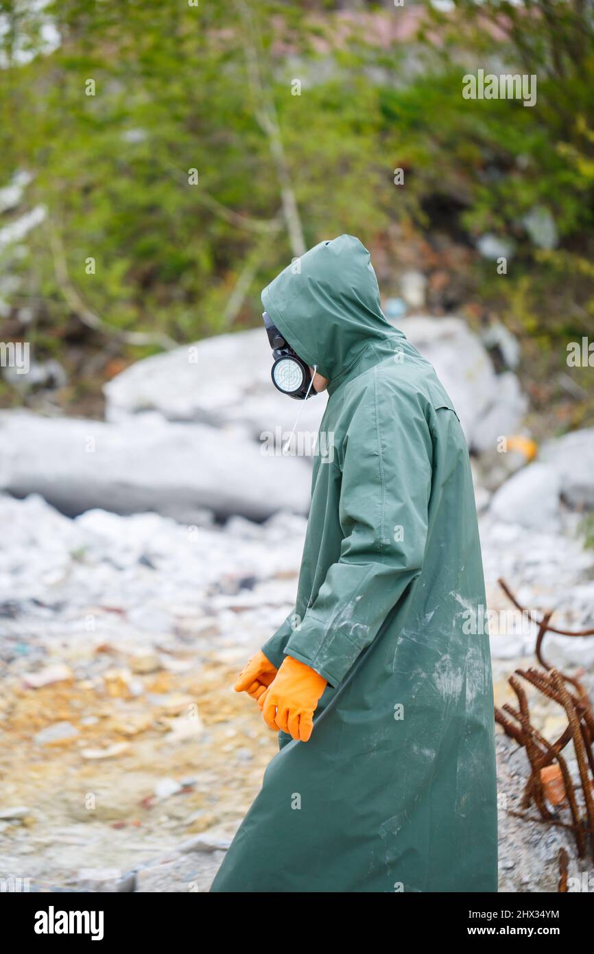 A man in a protective mask and protective clothing explores the danger ...