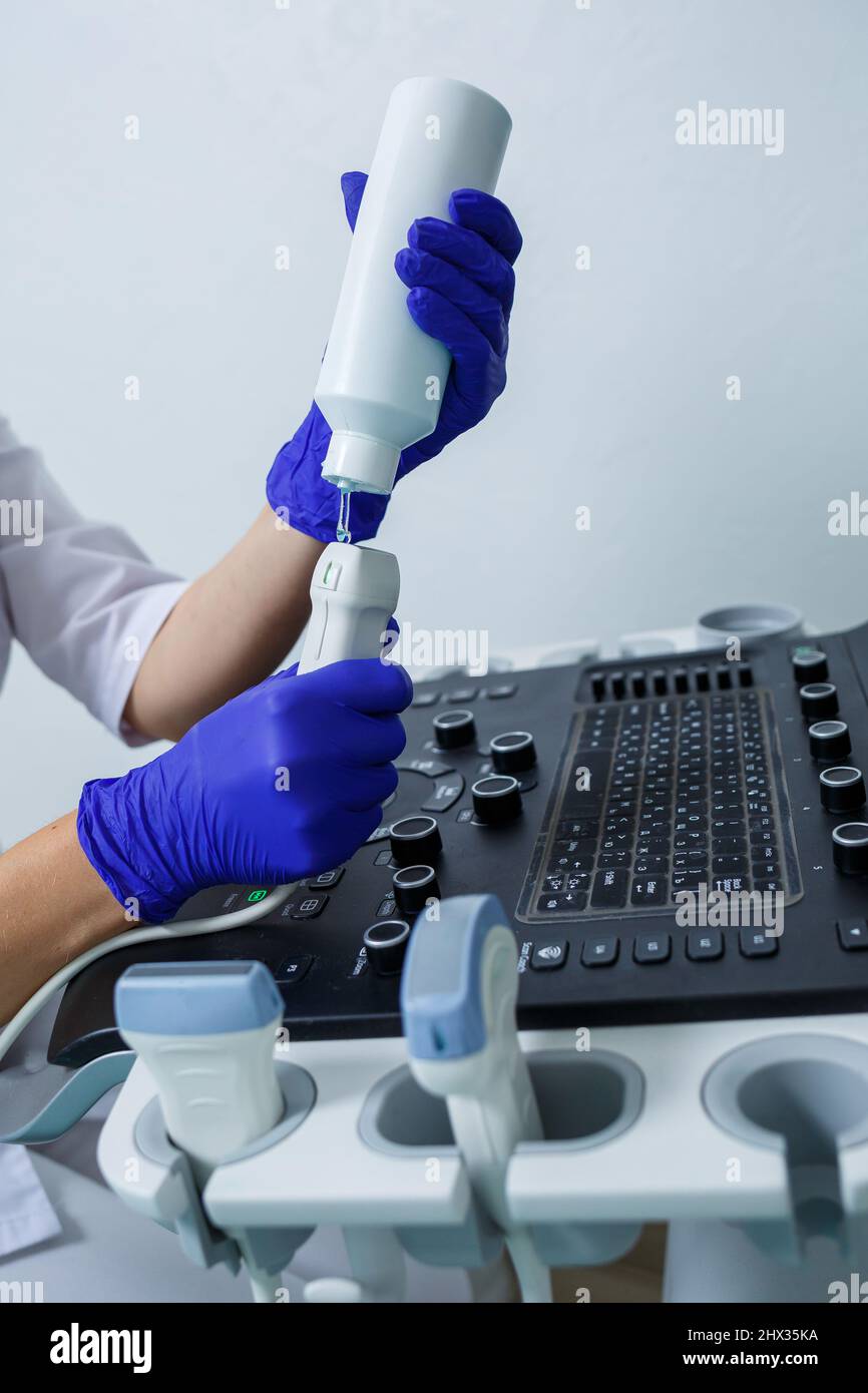 A close-up of the hands holding the ultrasonic probe of an ultrasound ...