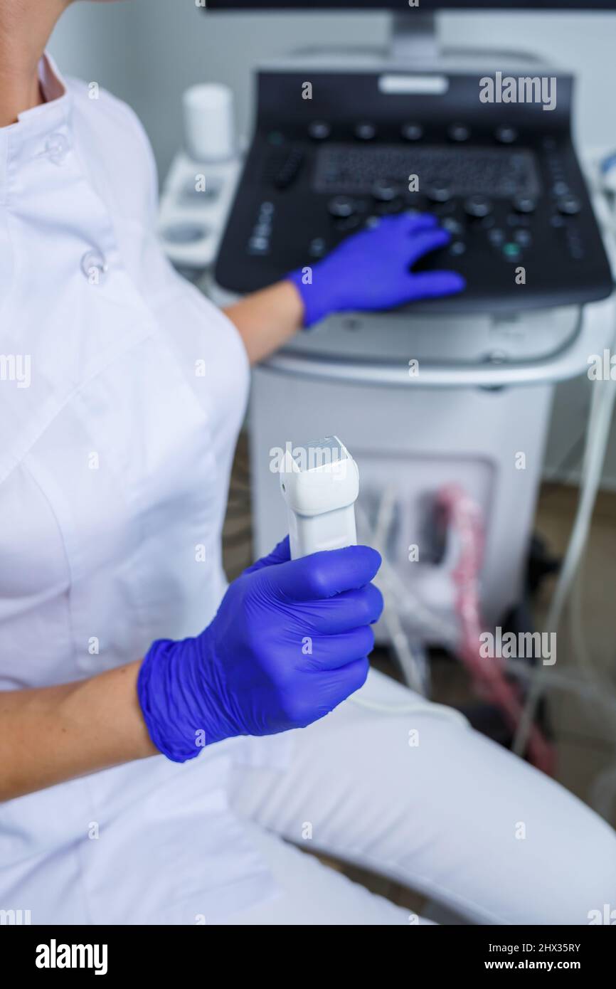 A young woman is an intern doctor, she is in a white suit and medical ...