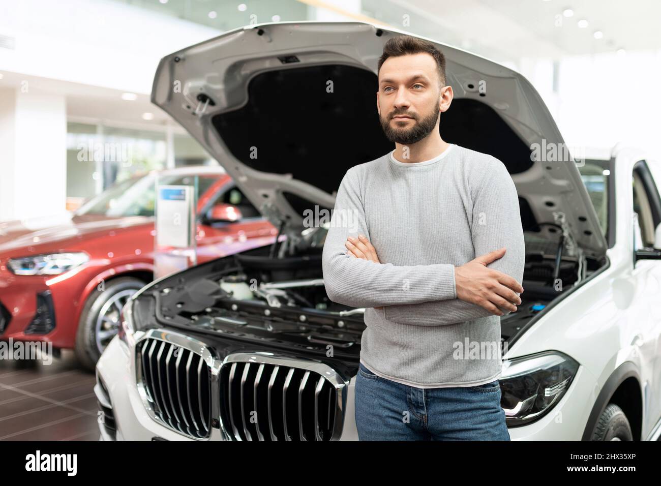a man in a car dealership understands the technical features of a new ...