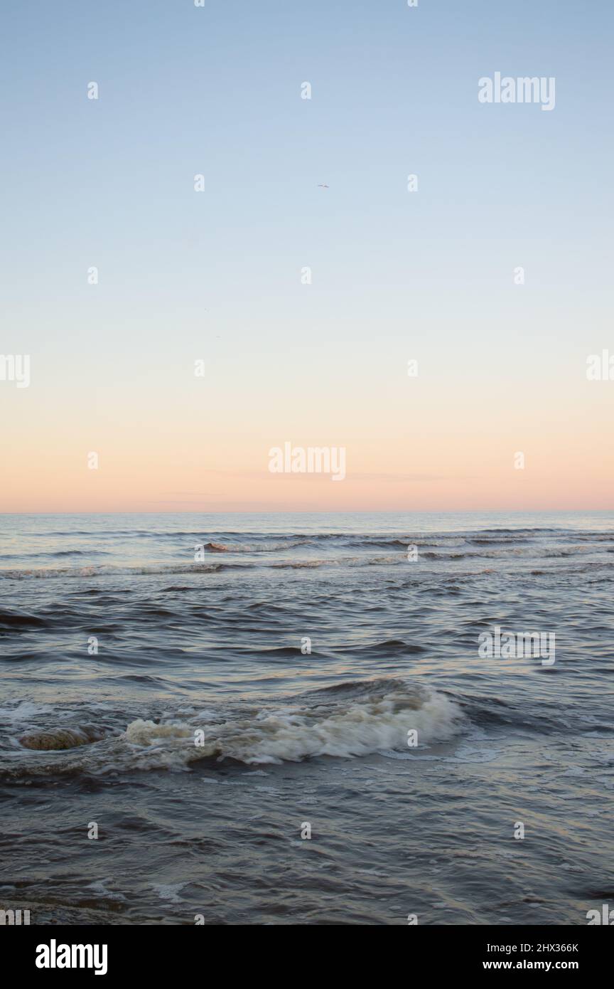 Seascape at sunset. Minimalistic cold sea view at sunset. Clear sky ...