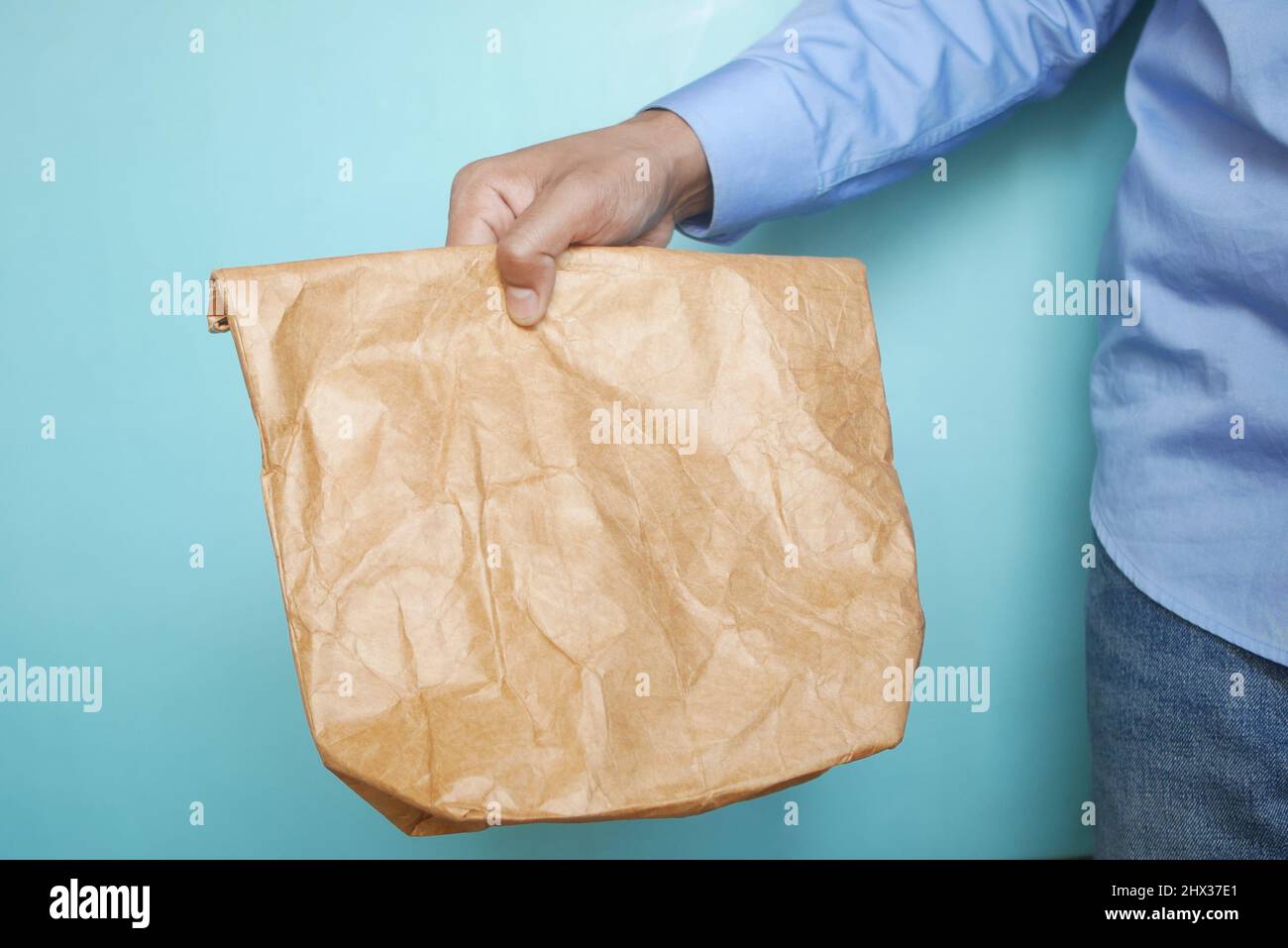 hand holding a paper lunch packet close up Stock Photo - Alamy