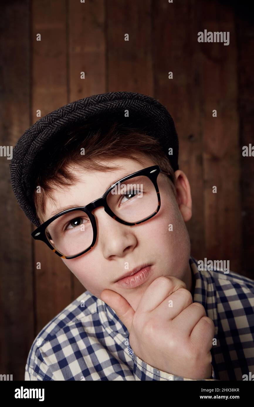Thinking things through. Young boy in retro clothing wearing spectacles ...