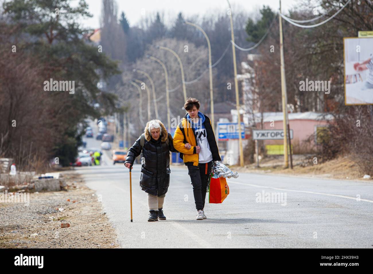 ZAKARPATTIA REGION, UKRAINE - MARCH 8, 2022 - A boy supports an elderly ...