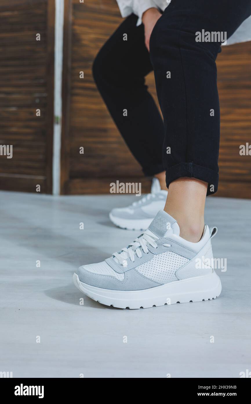 Beautiful women's shoes with legs, leather white sneakers, in the ...