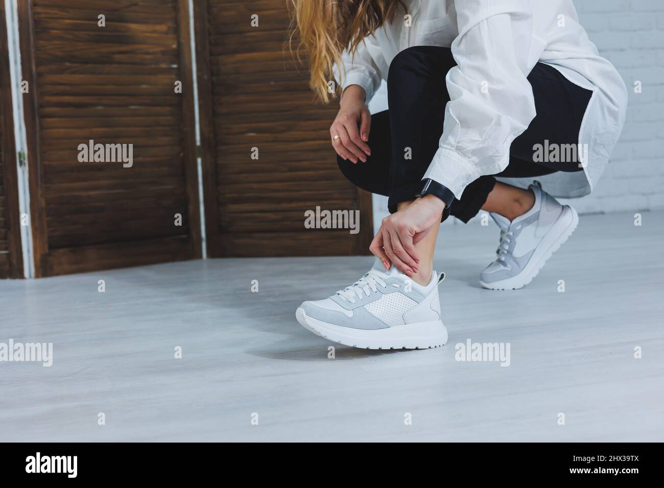 Beautiful women's shoes with legs, leather white sneakers, in the ...