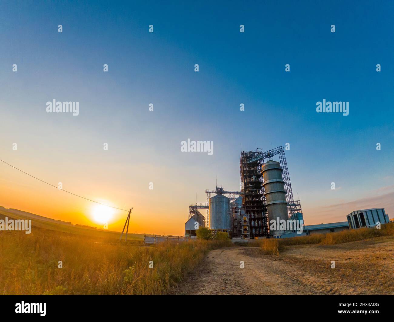 Grain storage station, shiny metal grain tanks at sunset. Sunset on ...