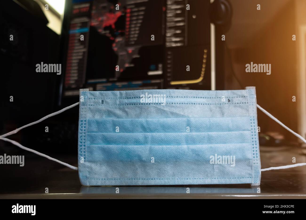 Protective medical mask on a monitor background with a virus spread map ...
