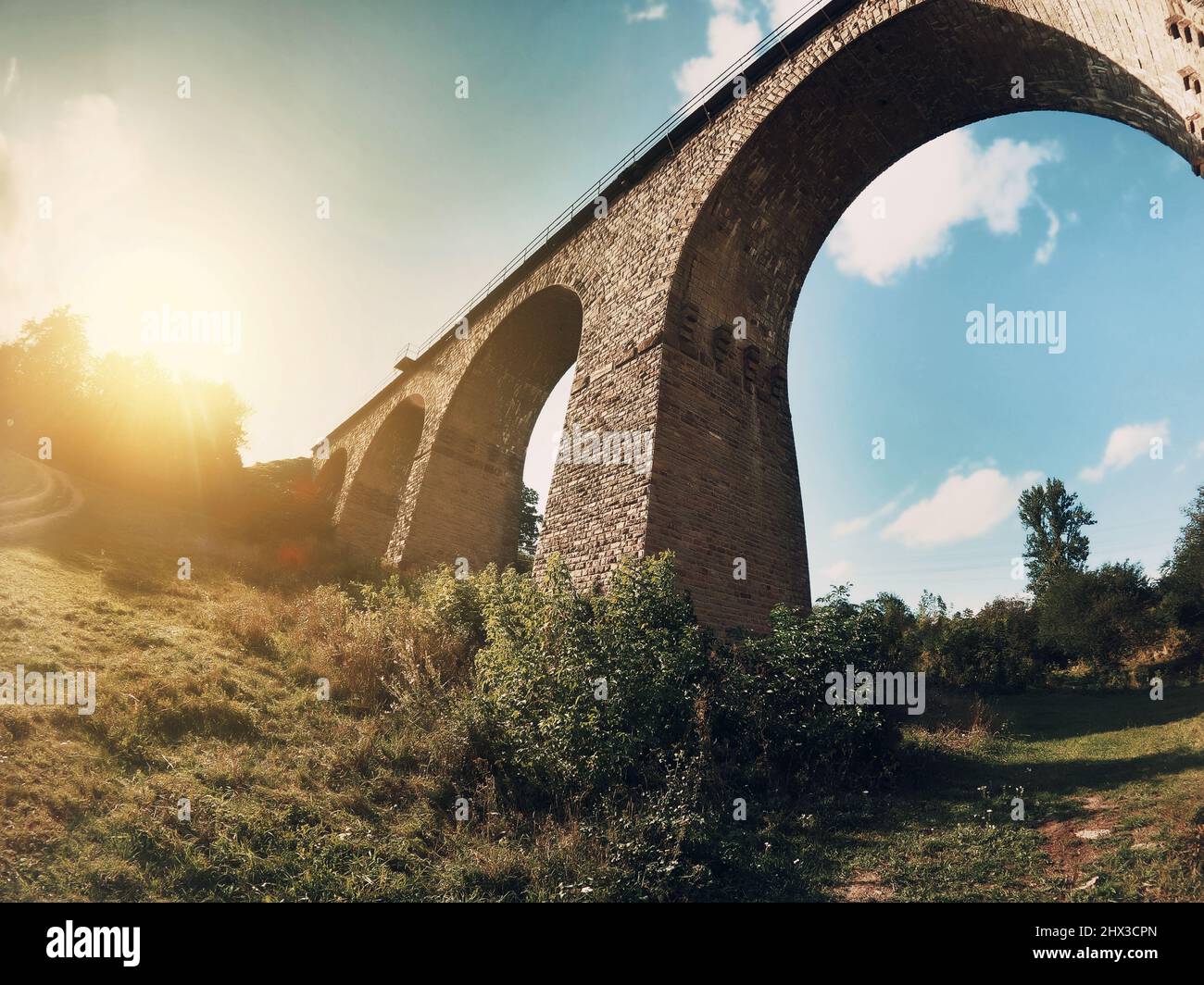 Old stone arched railway bridge. Bottom view. Sunny background Stock ...