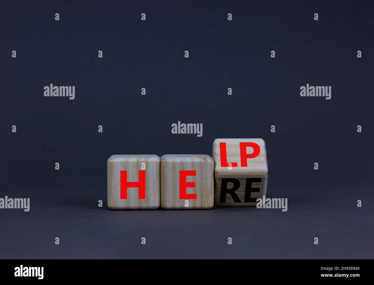 Help is here support symbol. Turned a wooden cube with concept word ...
