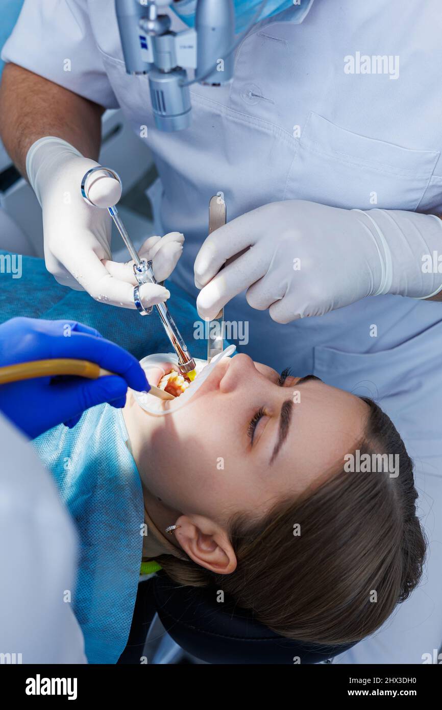 The dentist examines the patient's teeth using dental equipment. Modern ...