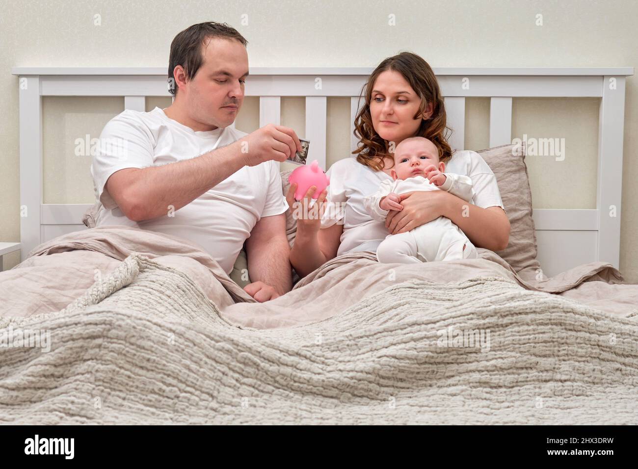 Mother and father with baby boy with money for upbringing, financial ...