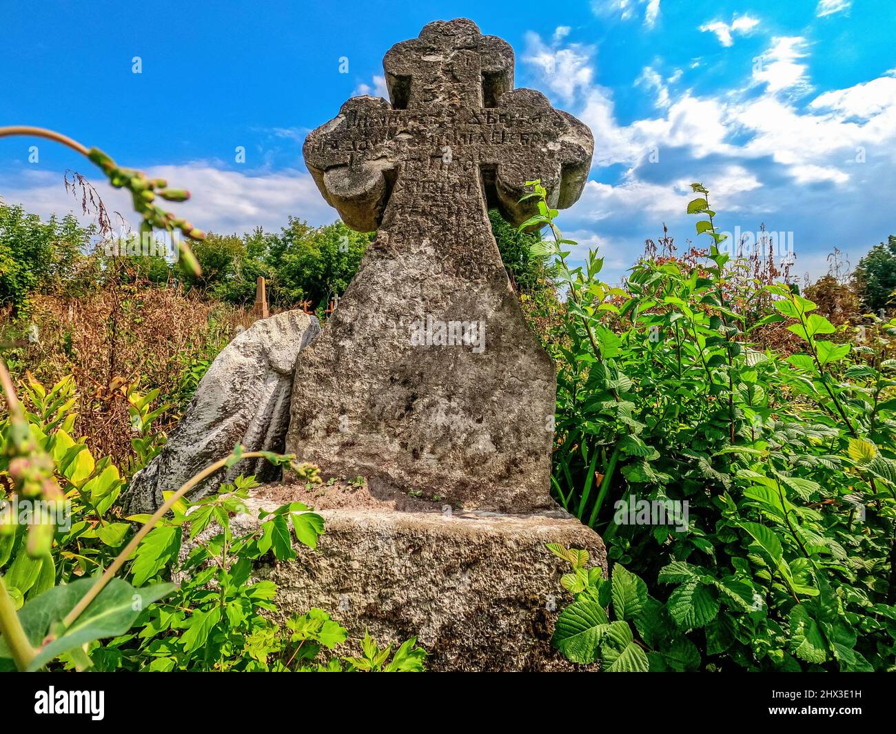 Front view of ancient stone cross in abandoned cemetery. Ancient ...