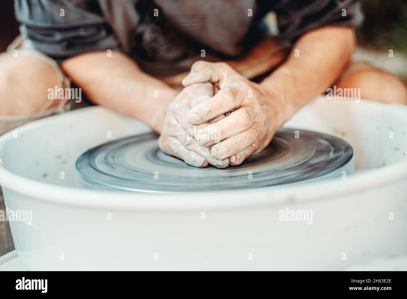 Potter wheel and potter hands, skilled hands of potter shaping the clay ...