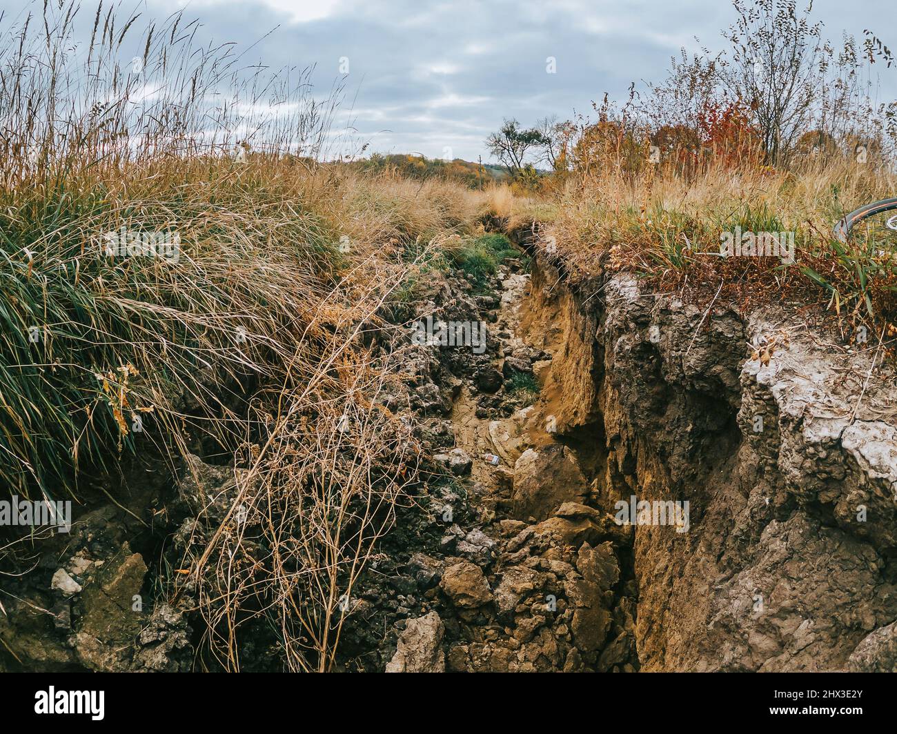 Deep crack in ground from earthquake. View of rift in meadow in ...
