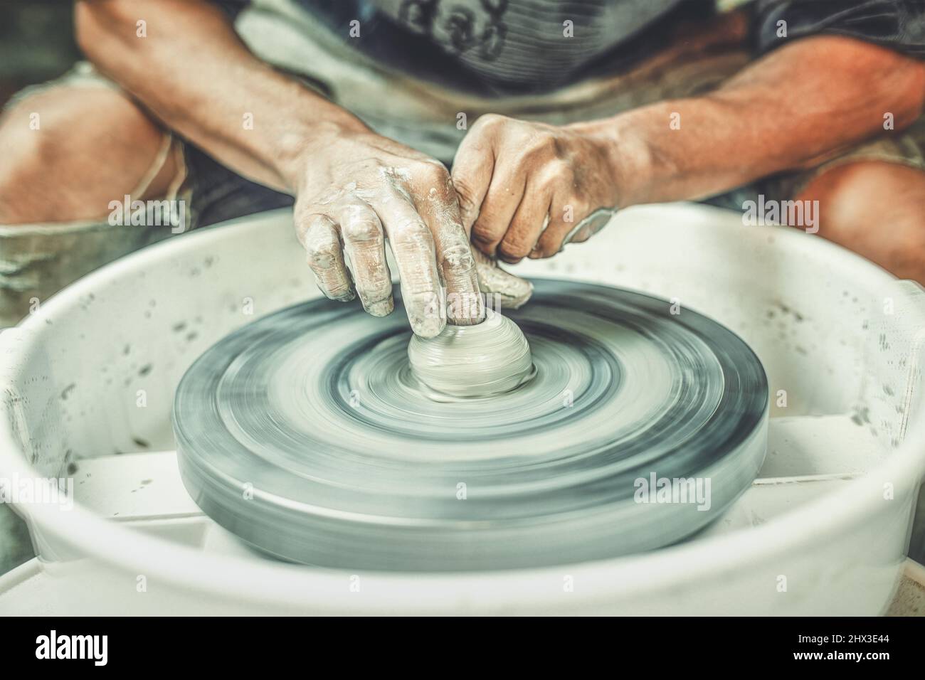 Potter wheel and potter hands, skilled hands of potter shaping the clay ...