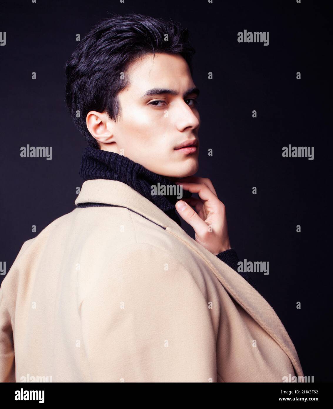 handsome asian fashion looking man posing in studio on black background ...