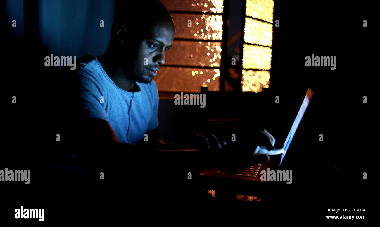African man browsing internet late at night in pitch dark Stock Photo ...