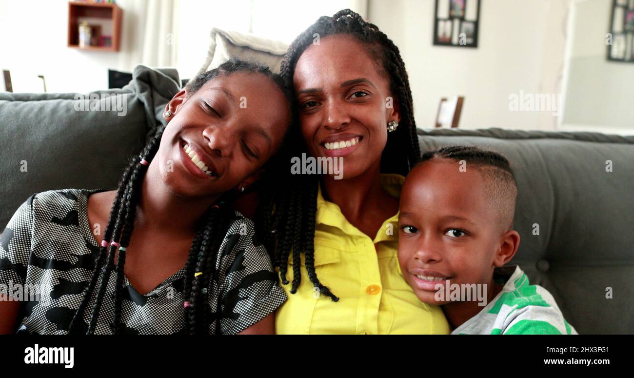 African mother and children sitting at home couch smiling. Family love ...