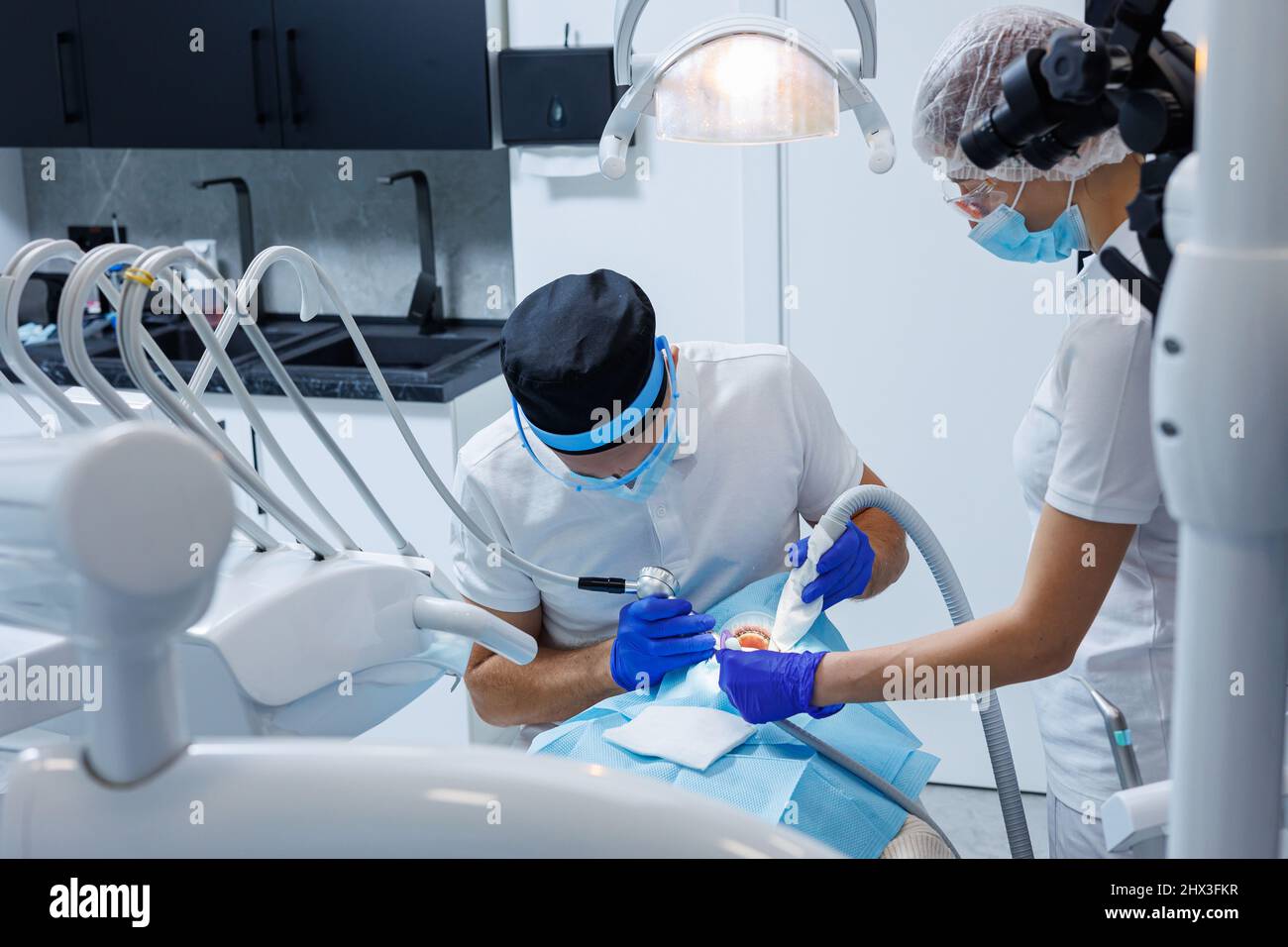 A professional dentist examines a patient's teeth with dental equipment ...
