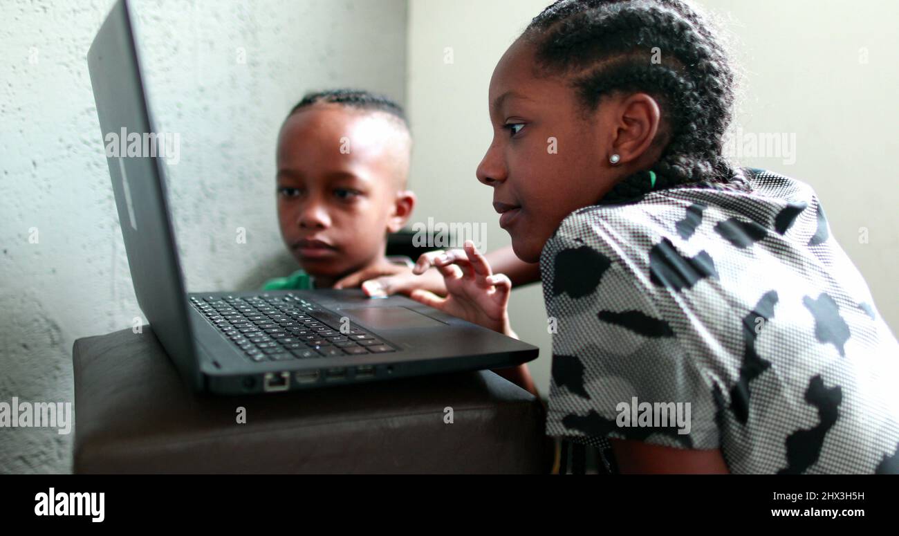 Children browsing the internet on laptop. little brother and sister in ...