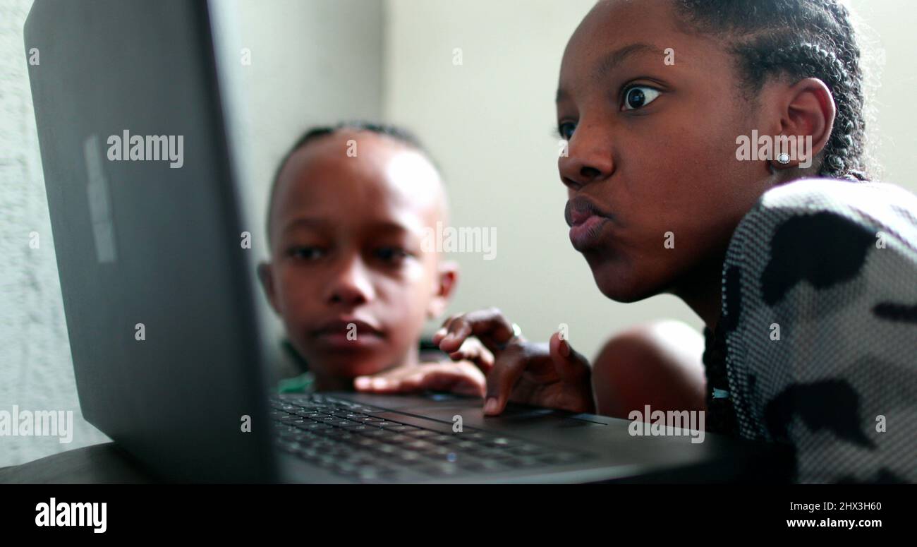 Children browsing the internet on laptop. little brother and sister in ...