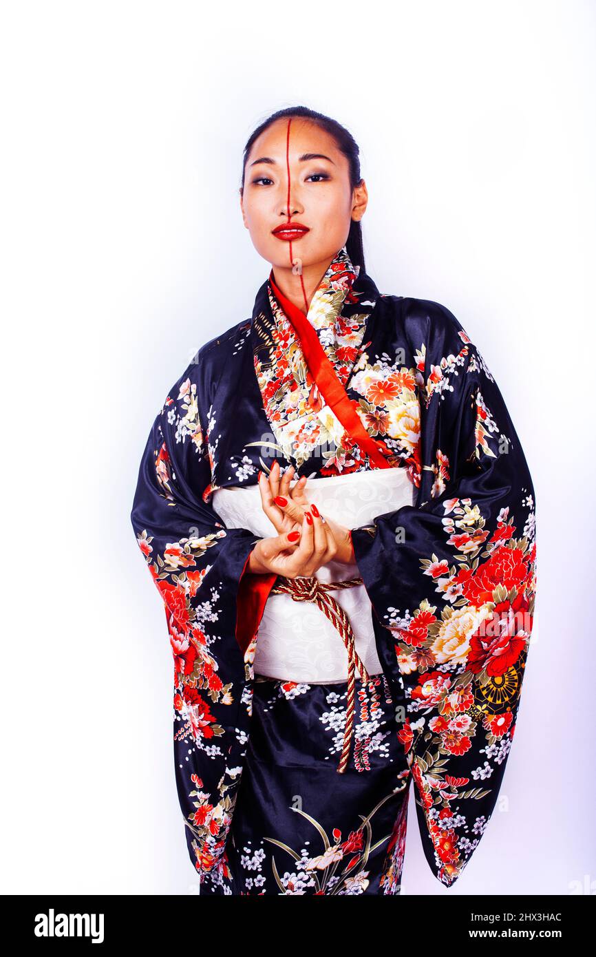 young pretty geisha in black kimono posing isolated on white background ...