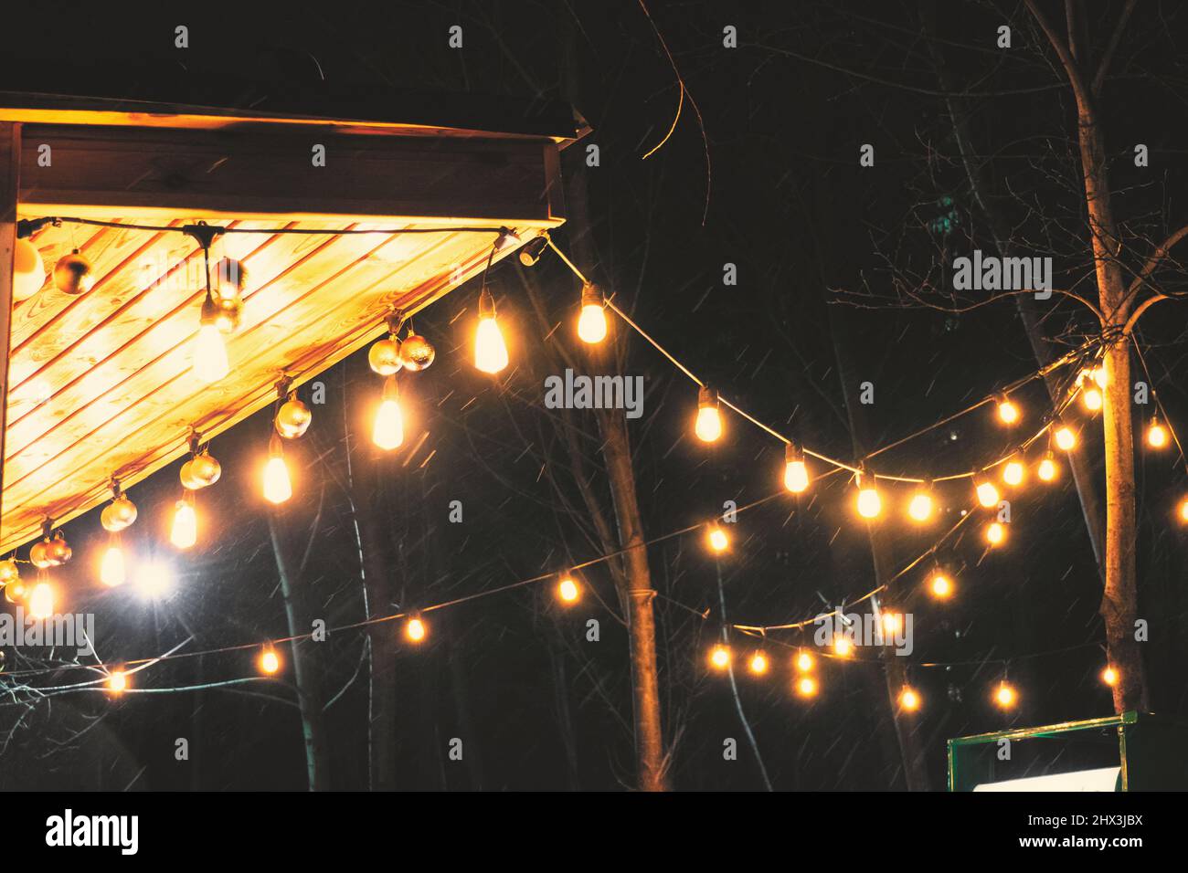 Warm light of street lamps against the background of falling snow Stock ...