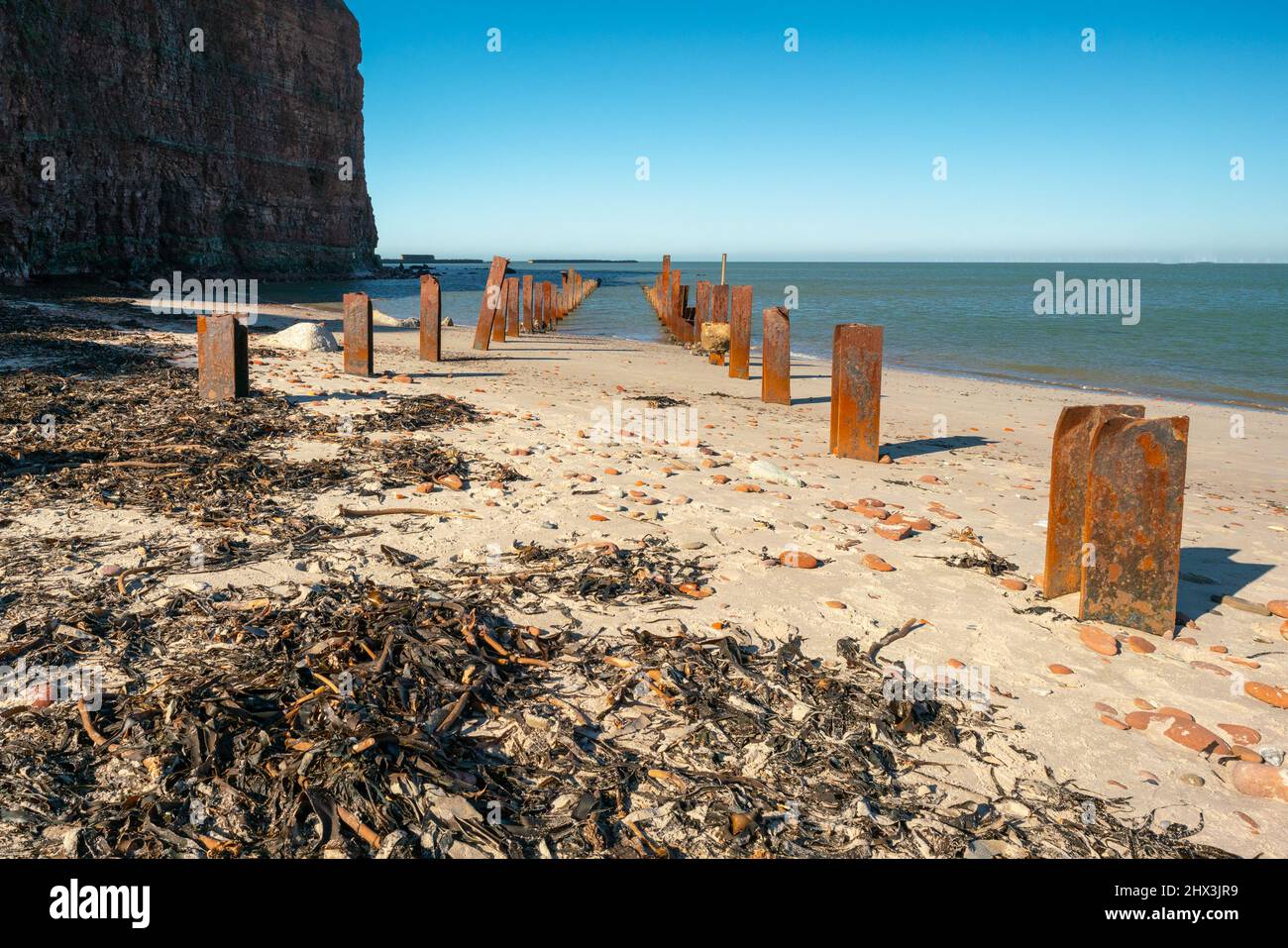 Rusty steel beams, remnants of old ocean pier, on the beach of ...