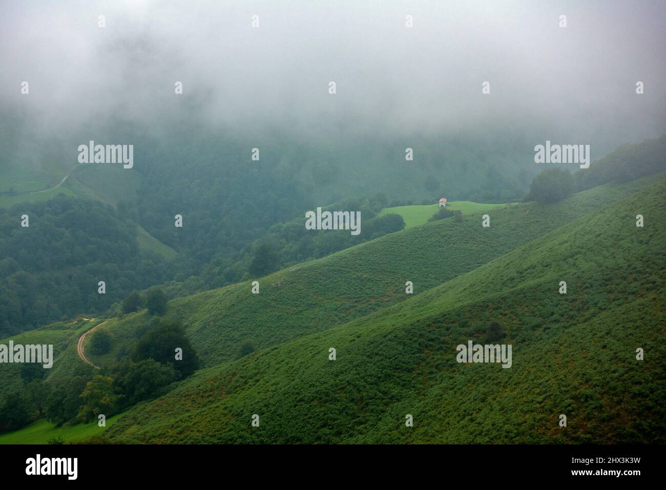 Small house in the misty Pyrenees mountains viewed from the Camino de ...
