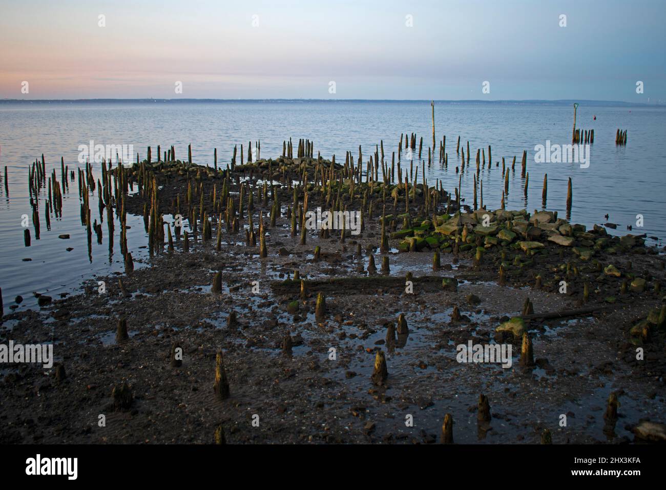 Low tide at Keyport Harbor exposes sand bar and old wooden posts ...