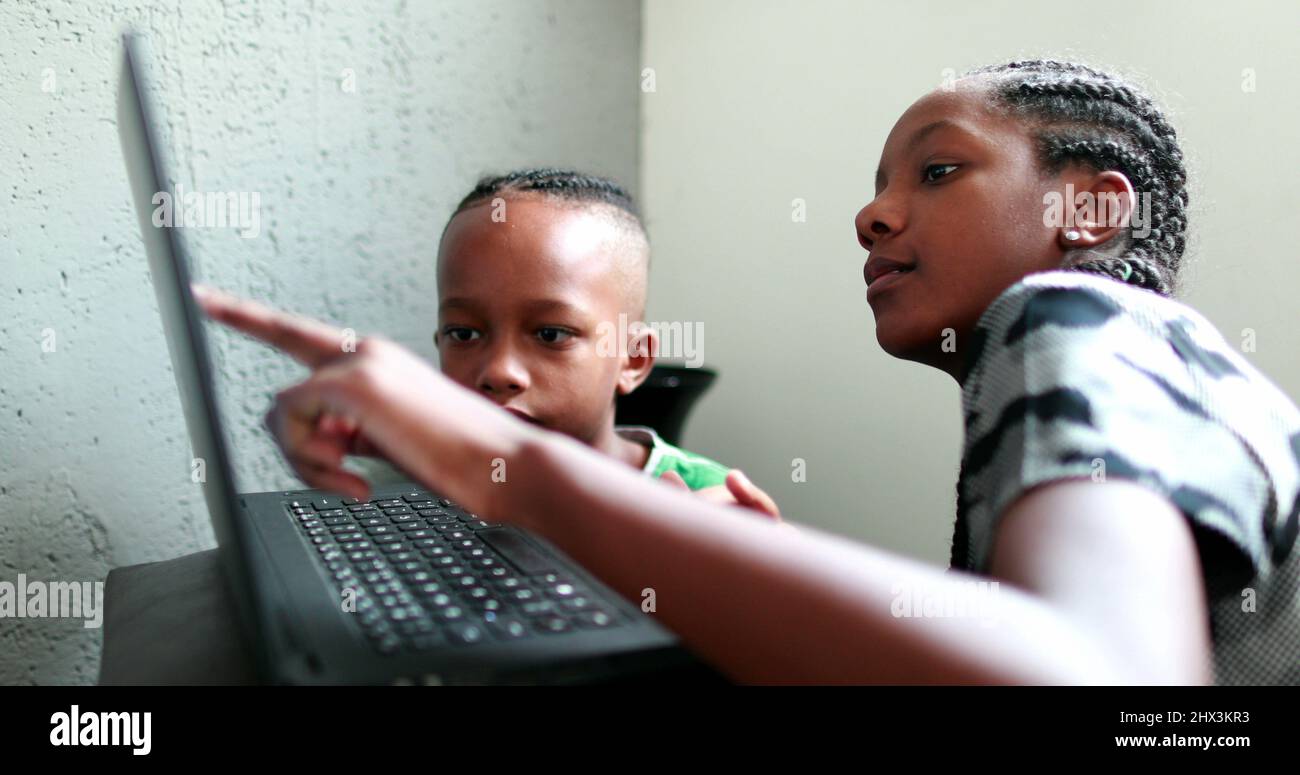 Teen girl pointing at laptop screen with finger, kids browsing the ...