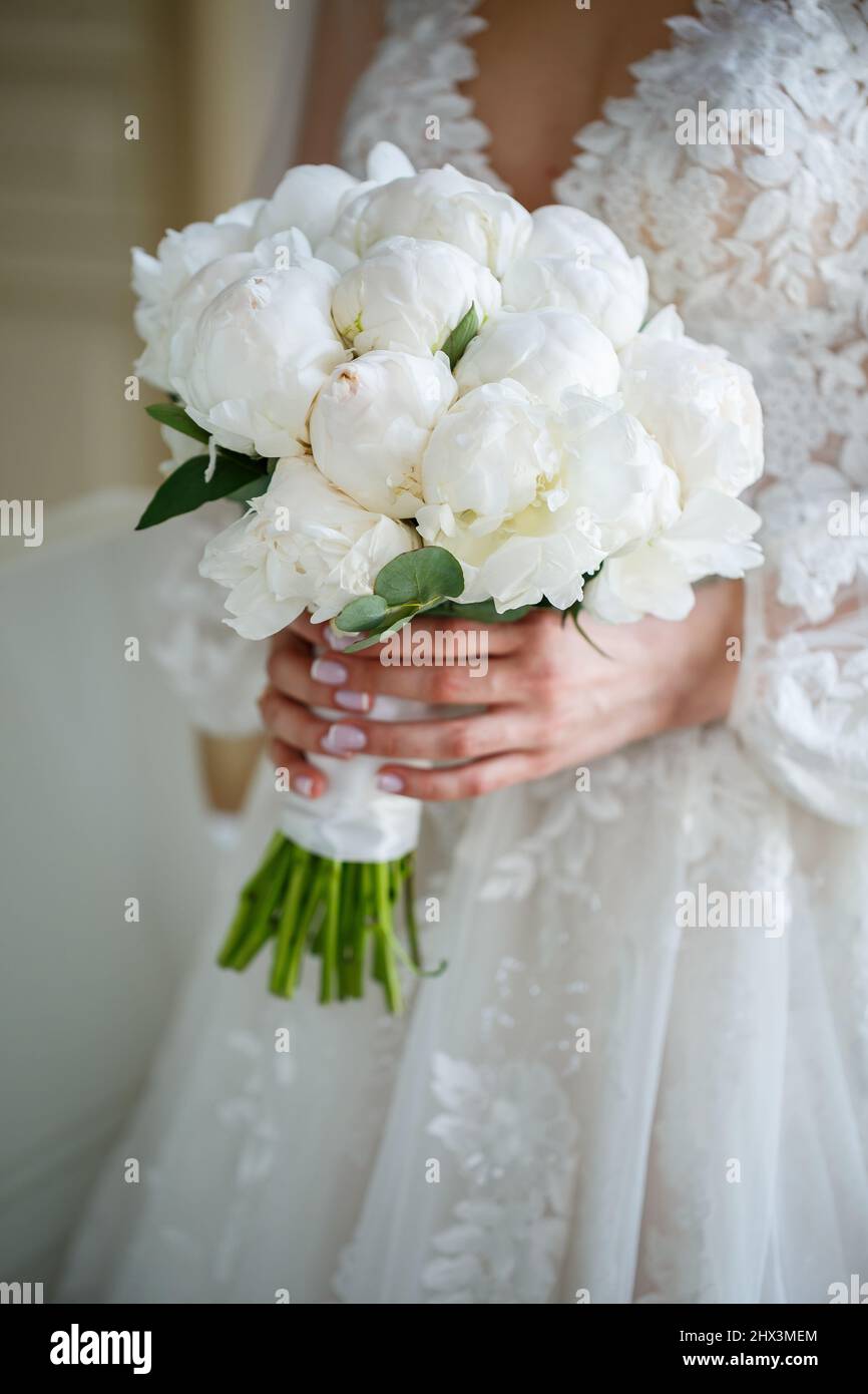 Hands of the bride close-up with a bouquet of fresh beautiful flowers ...