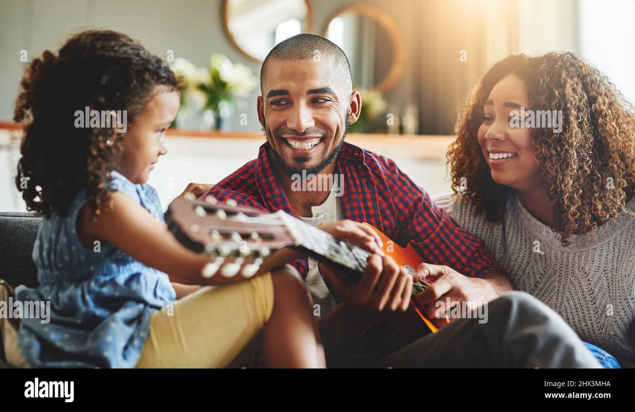 Tuned into family time. Shot of an adorable little girl and her parents ...