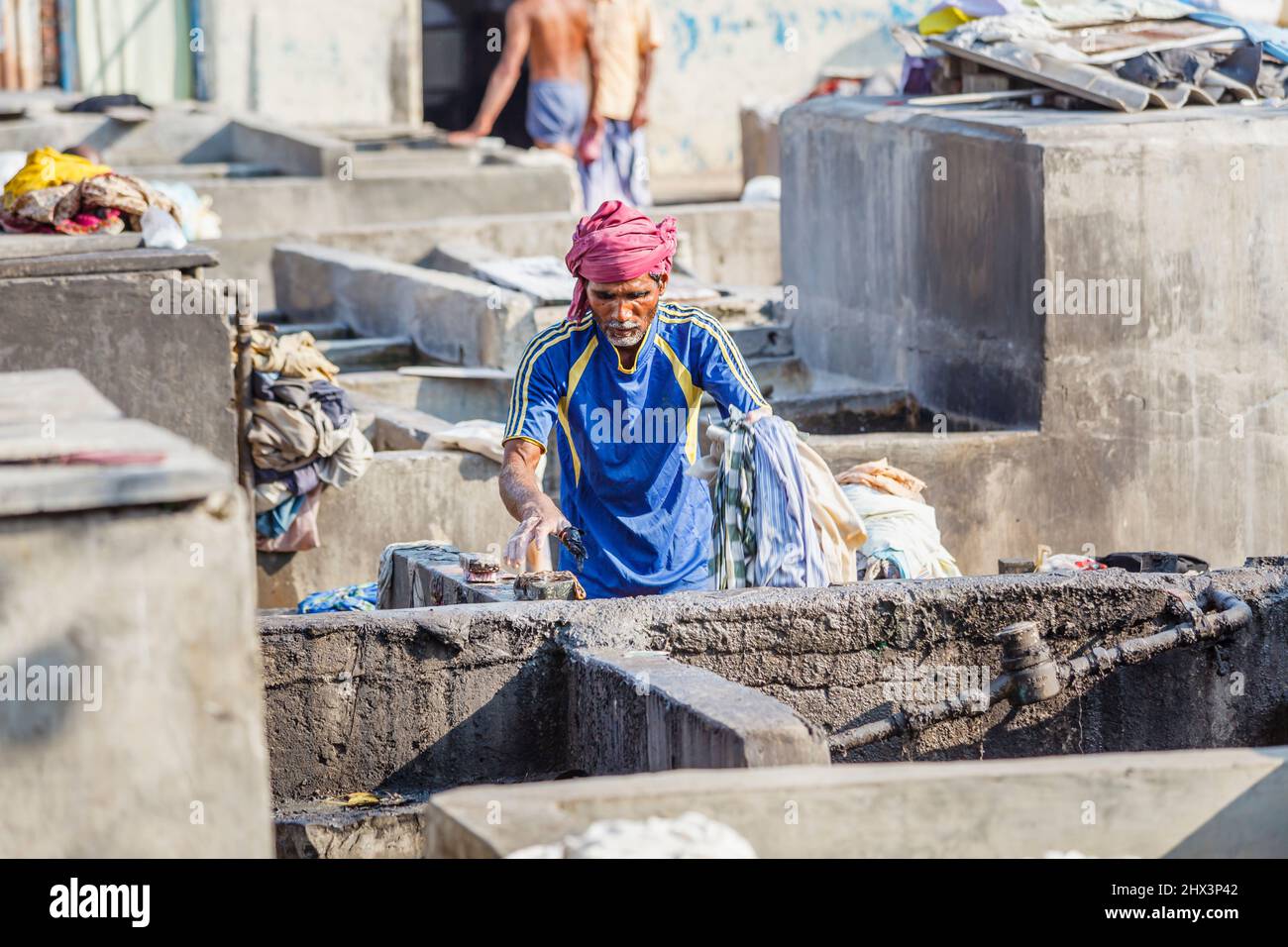 A dhobi wallah (washerman) works washing materials in a typical ...